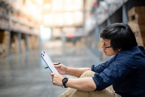 클립보드와 펜을 사용 하 여 창 고 선반에 골 판지 상자에 제품의 재고 조사를 하 고 젊은 아시아 남자 가리키기에 대한 스톡 사진 및 기타 이미지 Istock