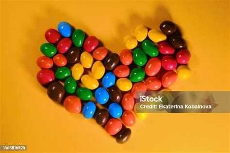 발렌타인 데이의 개념입니다 위에서 본 모습 플랫 레이 인사말 카드 화려한 달콤한 사탕이 하트 모양으로 배치됩니다 노란색 배경입니다 갈색에 대한 스톡 사진 및 기타 이미지