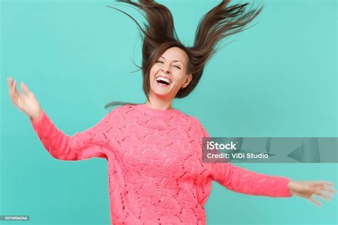 점프 확산 손 블루 벽 배경 스튜디오 초상화에 고립 된 머리를 나 부 끼고와 니트 핑크 스웨터에서 즐거운 젊은 여자 사람들이 진심으 감정 라이프 스타일 개념 복사 공간을