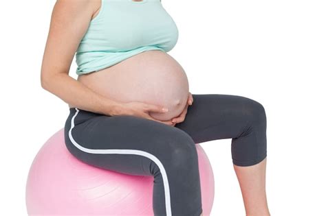 Pregnant Woman Sitting On Pink Exercise Ball Premium Photo