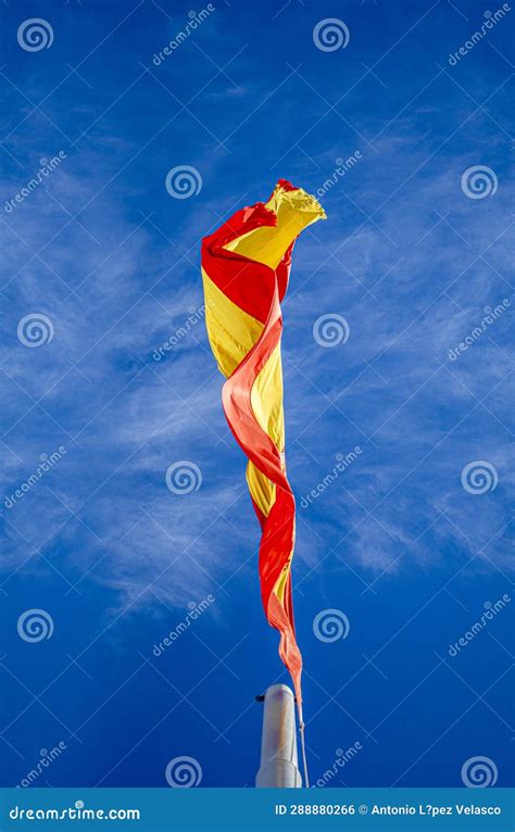 Flag Of Spain Waving In The Wind On A Flagpole With The Intense Blue