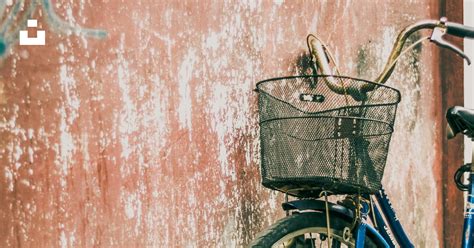 파란색과 검은 색 도시 자전거는 갈색 건물 벽 근처에 주차되어 있습니다 사진 Unsplash의 무료 자전거 이미지