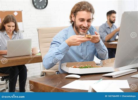Empleado De Oficina Que Come Pizza Para El Almuerzo En El Lugar De