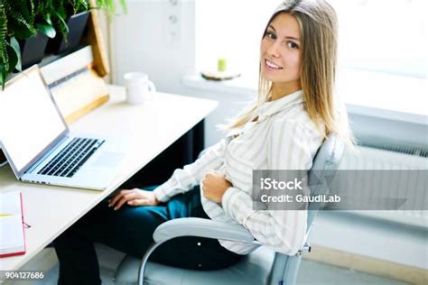 광고 텍스트 메시지에 대 한 빈 화면 영역과 현대 디지털 노트북 컴퓨터 장치와 데스크톱에 앉아 카메라를 보고 하는 얼굴에 미소와 아름 다운 크리에이 티브 디자이너의 초상화