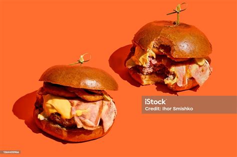 베이컨과 양파를 곁들인 햄버거 2개 녹은 치즈 오렌지 배경에 물린 햄버거 한 개 0명에 대한 스톡 사진 및 기타 이미지 0명 고기 구이 Istock