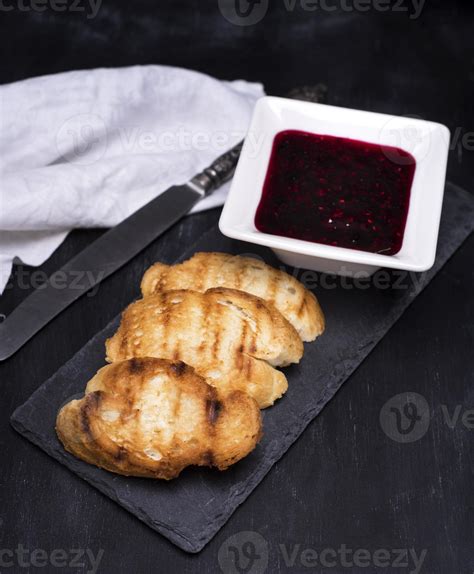 Tostadas De Pan Blanco Sobre Fondo Negro Y Mermelada De Frambuesa