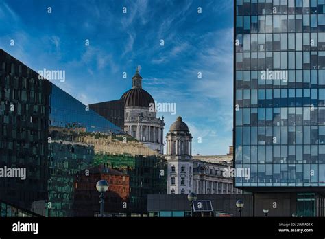 Urban Contrast With Old Dome Architecture Beside Modern Glass Building Under A Blue Sky With