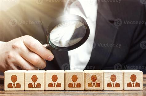 Businessman Examines A Magnifying Glass Blocks With Employees Analysis