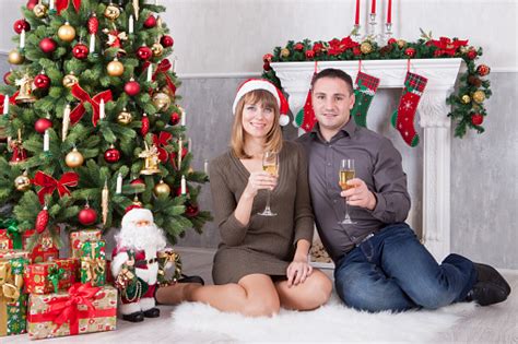 크리스마스 또는 새 해 축 하 아름 다운 영 커플 크리스마스 선물 크리스마스 트리 근처에 앉아 샴페인 잔 배경에 스타킹 크리스마스와 벽난로 2명에 대한 스톡 사진 및 기타
