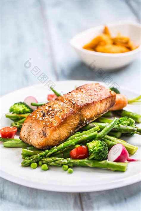 烤鲑鱼牛排配花椰菜胡萝卜西红柿萝卜青豆和 包图企业站