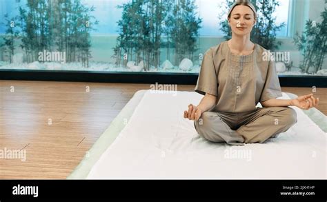 Attractive Woman Sitting In Lotus Pose Or Asana Padmasana On Yoga Mat