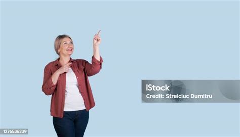 수석 백인 여자 금발 머리 가리키는 에 이 푸른 스튜디오 무료 공간 근처 그녀의 검지 손가락 손가락에 대한 스톡 사진 및 기타 이미지 Istock