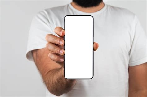 평범한 흰색 스마트폰을 들고 있는 모델 무료 사진