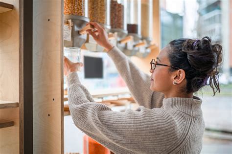 30대 히스패닉 여성 지속 가능한 제로 폐기물 가게에서 항아리를 보충하기 위해 디스펜서 사용 30 34세에 대한 스톡 사진 및 기타 이미지 Istock