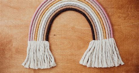 나무 테이블에 세련 된 마크라메 무지개 장식입니다 아기 방 또는 간단한 세련된 소녀 방을 위한 현대 Boho 로프 무지개 벽걸이 마크라메 장식 사진 Unsplash의