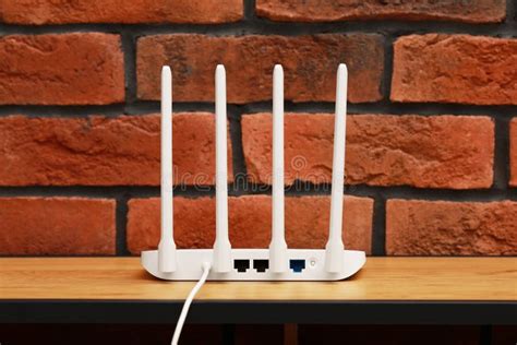 New White Wi Fi Router On Wooden Table Near Brick Wall Stock Image