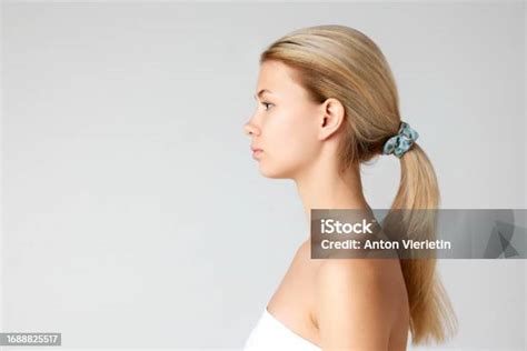 회색 스튜디오 배경 위에 고립된 맨 어깨로 서 있는 포니테일을 한 어린 금발 소녀의 측면 모습 18 19세에 대한 스톡 사진 및 기타 이미지 Istock