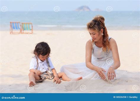 Азиатская мама и сын играя на пляже Стоковое Фото изображение насчитывающей счастливо счастье