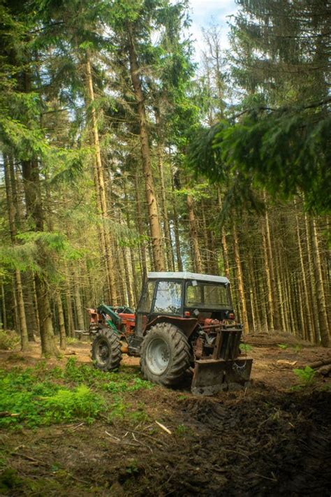Vertical Shot Of A Logging Tractor Parked In A Forest Editorial Stock Image Image Of Machinery