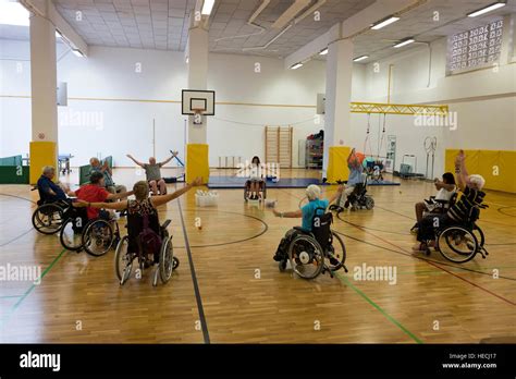 An Exercise Class In A Sports Hall For Wheelchair Users Lead By A Woman