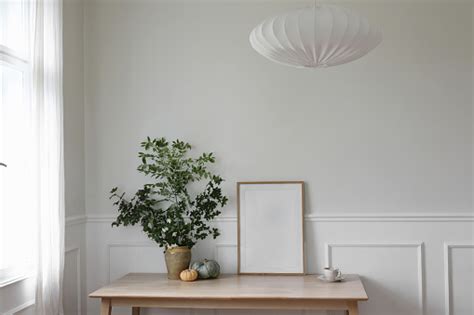 우아한 스칸디나비아 거실 인테리어 홈 오피스 나무 포스터 테이블 위에 사진 프레임 모형 꽃병 호박 커피 한 잔에 녹색 나뭇 가지 직물 램프 그늘 추수 감사절 가정 장식 0