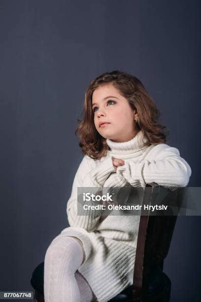 가벼운 스웨터 및 얇은 명주 그물 치마에 갈색 머리를 가진 작은 아름 다운 소녀 스튜디오입니다 공주는 사진 작가 대 한 포즈 귀여운에 대한 스톡 사진 및 기타 이미지
