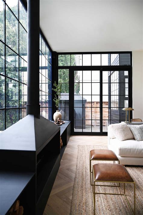 A Grid Of Square Black Window Frames Cover The Back Wall Of This
