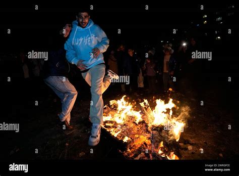 A Man Jumps Over A Bonfire As People Celebrate Chaharshanbe Souri Or