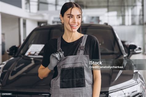 젊은 여자 전문 여성 정비공의 초상화 자동차 수리점에 서있는 카메라에 미소 짓고 있습니다 자동차 서비스 수리 유지 보수 및 사람들 개념 25 29세에 대한 스톡 사진 및