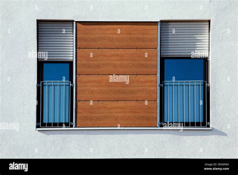 Two Windows Side By Side Next To Each Other On White Wall Of An Apartment Building With European
