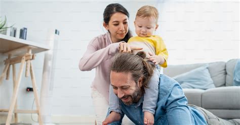 백인 행복 하 고 사랑하는 부모는 거실에서 아기 유아와 놀고 있습니다 매력적인 부부 아버지는 어린 어린 유아 아들 아이를 목에 걸고 어머니를 바닥에 안고 있다 집에서