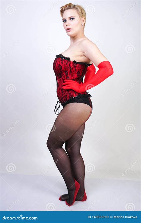 Plus Size Woman With Short Hair In A Red Lace Bodice And Sheer Classic Black Pantyhose With A