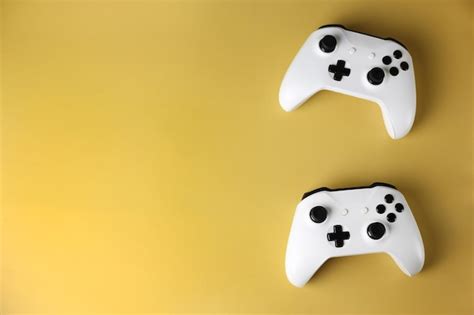 Premium Photo Two Gaming Gamepads On The Side On An Isolated Yellow Background