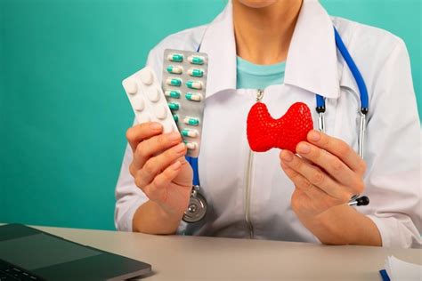 Premium Photo Doctor Holds Model Of Thyroid Gland And Pills Closeup