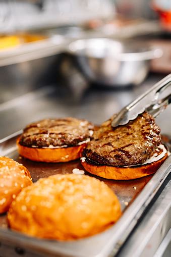 여자 요리사는 레스토랑 주방에서 야채와 고기를 곁들인 햄버거를 손으로 요리한다 고기에 대한 스톡 사진 및 기타 이미지 고기 공란 달걀 Istock