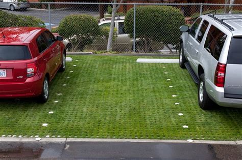Two Cars Parked On The Grass In Front Of A Fence