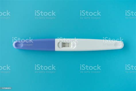 흰색 플라스틱 임신 테스트는 파스텔 연한 파란색 배경에 격리된 두 개의 줄무늬 결과로 양성입니다 근접 촬영 하향식 보기 2명에