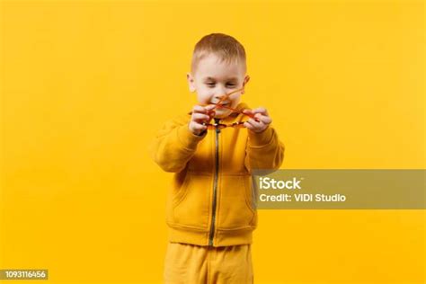 귀여운 꼬마 소년 34 년 된 노란색 옷을 입고 밝은 오렌지 벽 배경 어린이 스튜디오 초상화에 고립 사람들이 진심으 감정 어린 시절 라이프 스타일 개념 복사 공간을 비웃는