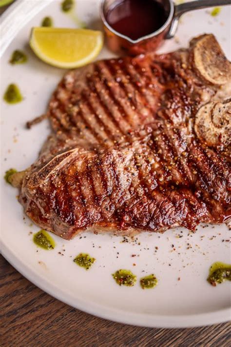 고기 고기 애호가 고기의 절단 고명 과즙이 많은 그릴 녹색 소스 다정한 단백질 드문 레몬 레스토랑 맛있는 먹음직스러운 메인 코스 미디움 레어