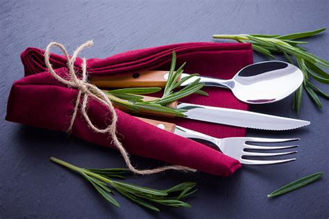 칼 세트입니다 칼 숟가락 슬레이트 돌에 포크 버건디 냅킨과 꼬기와 함께 크립토러리 검은 배경에 로즈마리 공간을 복사합니다 맨 위 보기 0명에 대한 스톡 사진 및 기타 이미지