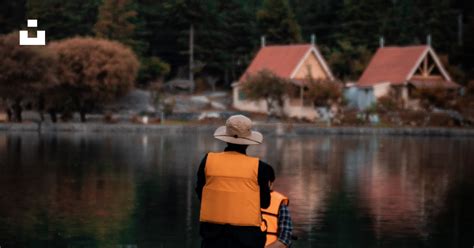 노란 재킷과 파란색 데님 청바지를 입은 남자가 낮에 물가에 서 있다 사진 Unsplash의 무료 스카르두 이미지