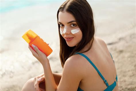 Premium Photo Beautiful Woman Applying Cream Sunscreen On A Tanned Face Sunscreen