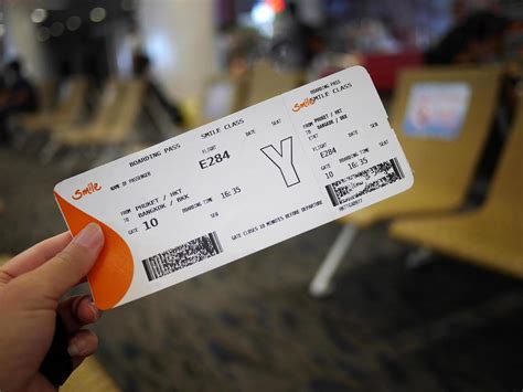 A Hand Holding Domestic Flight Boarding Pass With Blurry Airport Terminal Background 10852224