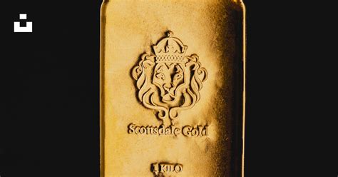 나무 테이블 위에 앉아 있는 금괴 더미 사진 Unsplash의 무료 금 이미지