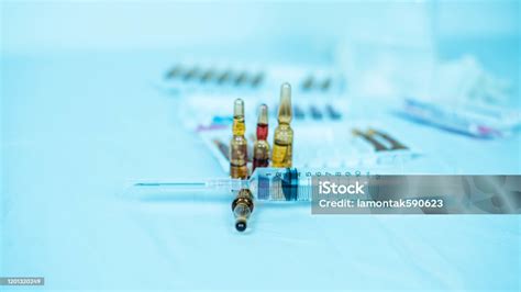 복사 공간이있는 파란색 배경의 의료 병 바이알 주사기 및 얼굴 마스크 예방 접종 세션 및 면역 개선 예방 접종 개념 의료 병원