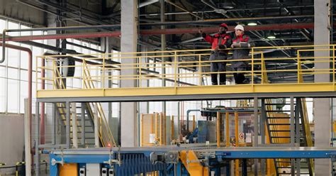 보호복을 입은 다민족 동료들이 다리 위에 서서 공장 공정을 통제하고 있다 사진 Unsplash의 공장 이미지