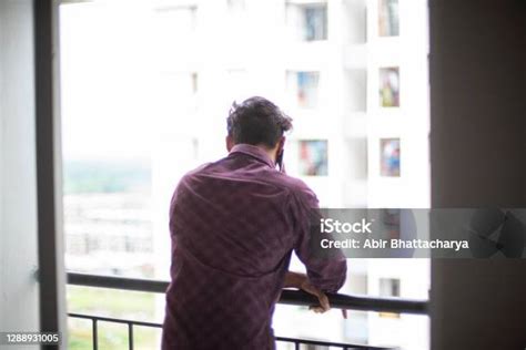 흰색 도시 배경의 발코니에 서 캐주얼 셔츠와 청바지에 젊고 잘 생긴 갈색 머리 벵골어 근육 남자의 뒷면 초상화 20 24세에 대한 스톡 사진 및 기타 이미지 Istock