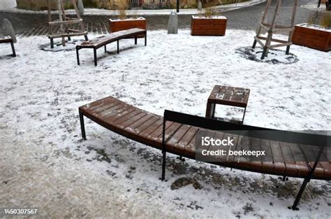 광장의 나무 아래 포장 도로에 더럽고 차가운 흔들 의자 공원에 있는 1인용 열대 나무로 만든 나무 데크 의자 눈 큐브 갈색 판자로 만든 편안한 판자 칸막이 강철 프레임