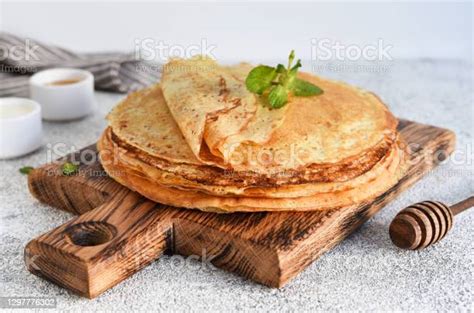 콘크리트 배경에 나무 보드에 사워 크림과 꿀얇은 팬케이크의 스택 팬케이크에 대한 스톡 사진 및 기타 이미지 팬케이크