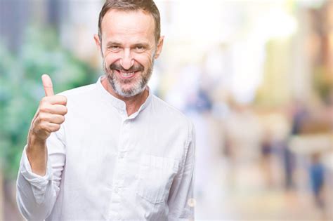 중 년 행복 엄지손가락 손으로 제스처를 하 고 격리 된 배경 위에 노인의 수석 남자 승인 성공을 보여주는 카메라를 보고 하는 식 긍정적인 감정 표현에 대한 스톡 사진 및